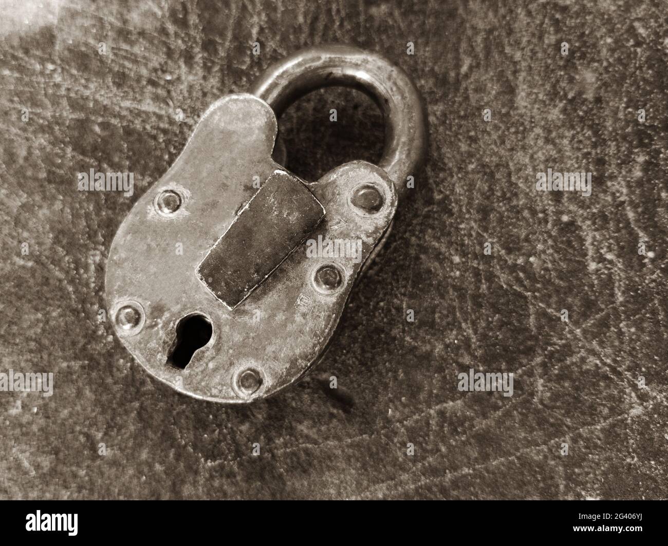 Closeup of an old padlock on a scratched gray metal surface with copy ...