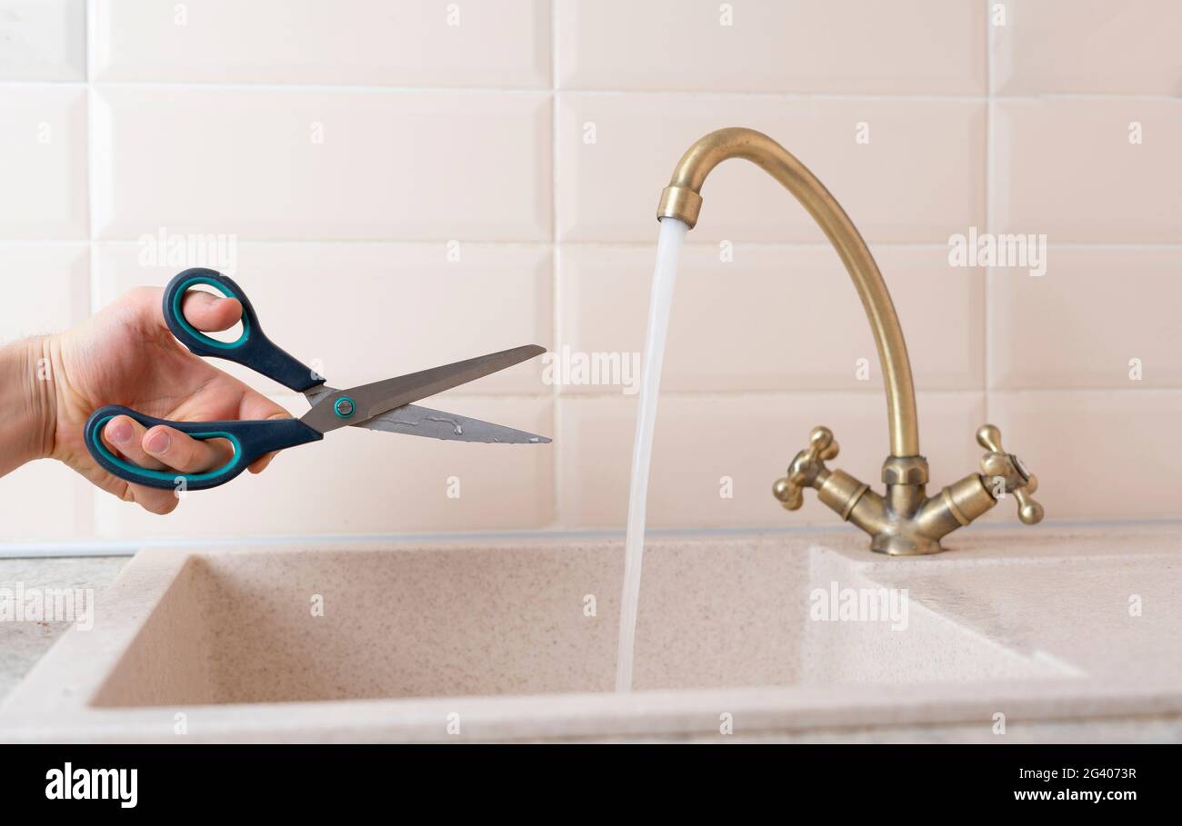 reduce water concumption concept, person cut the water stream from ...
