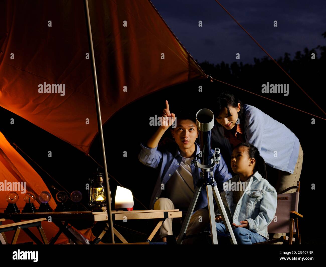 A happy family of three using telescopes outdoors high quality photo ...