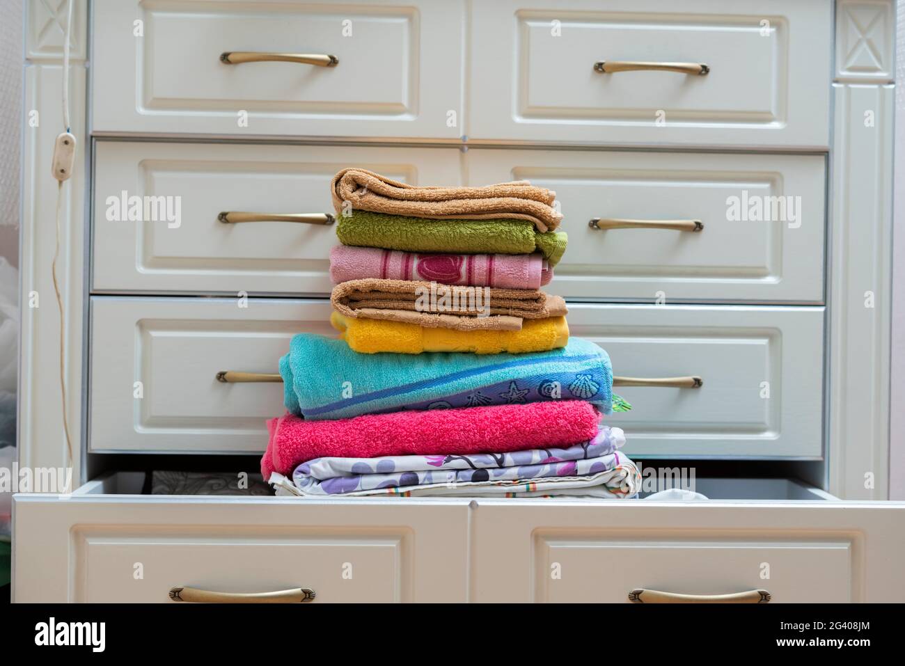 stack of new clean fresh color towels textile on the shelf in laundry ...