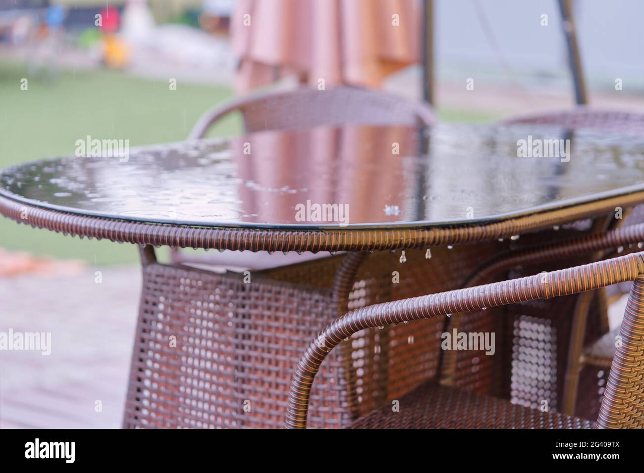 Coffee table and chair under the rain on the backyard Stock Photo - Alamy