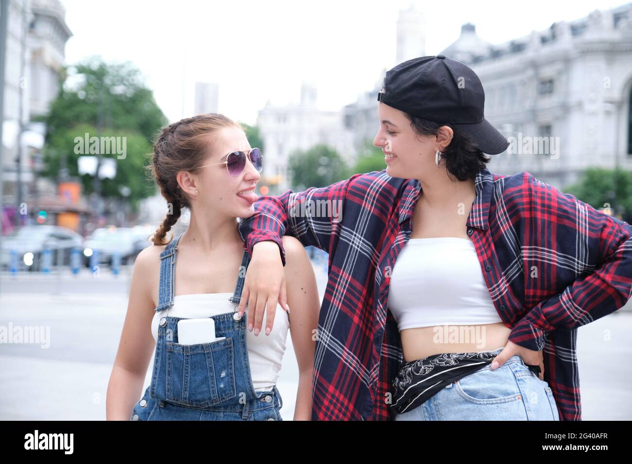 Two cool women smiling and sticking out tongue to each other. Two ...
