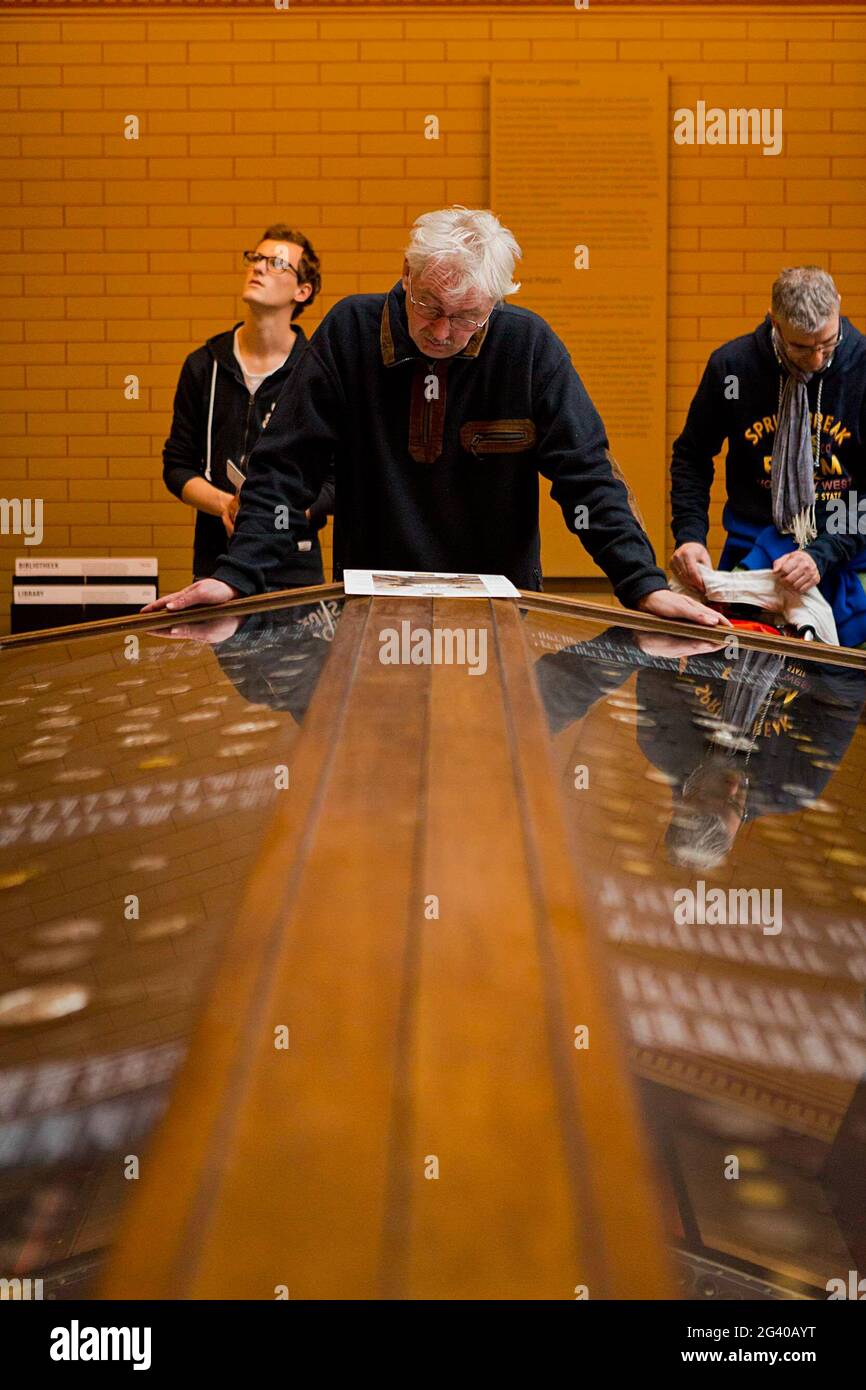 Visitor view a data sheet on the display case with coins and tokens ...