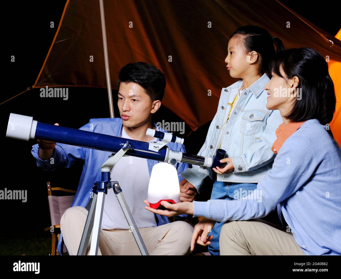 A happy family of three using telescopes outdoors high quality photo ...