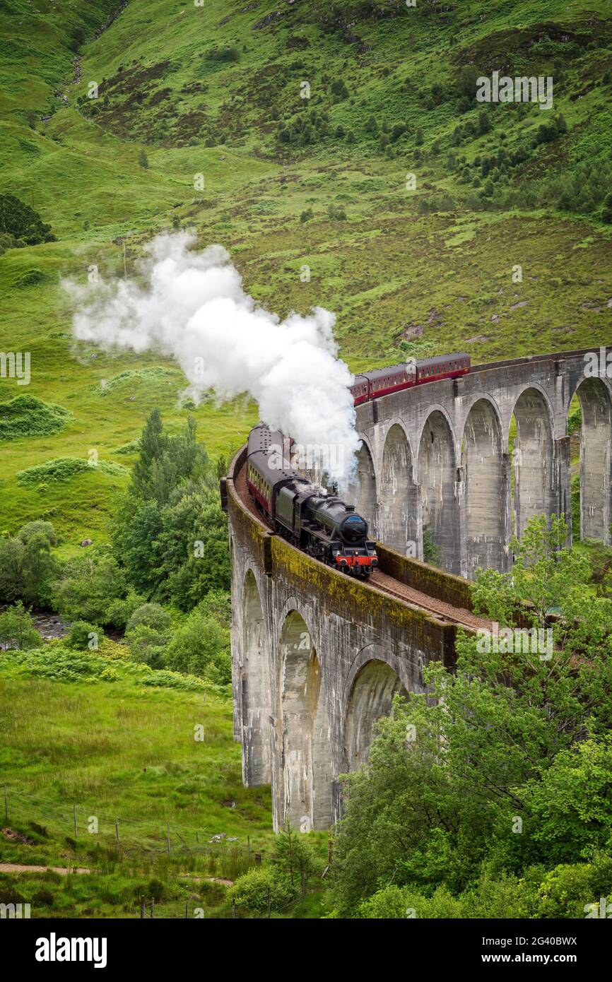 A vintage steam train crosses the Glenfinnan Viaduct at Loch Shiel ...