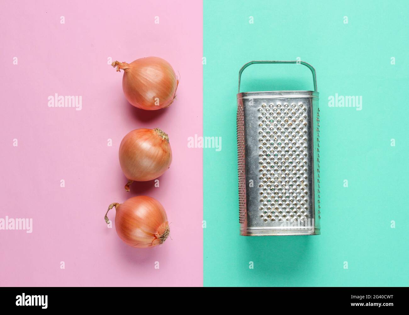 Old grater and onion bulbs on pastel background. Top view. Minimalistic ...