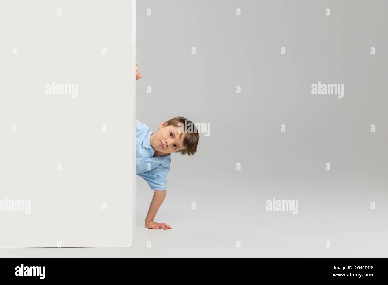 Half-length portrait of Caucasian little boy posing isolated over gray ...