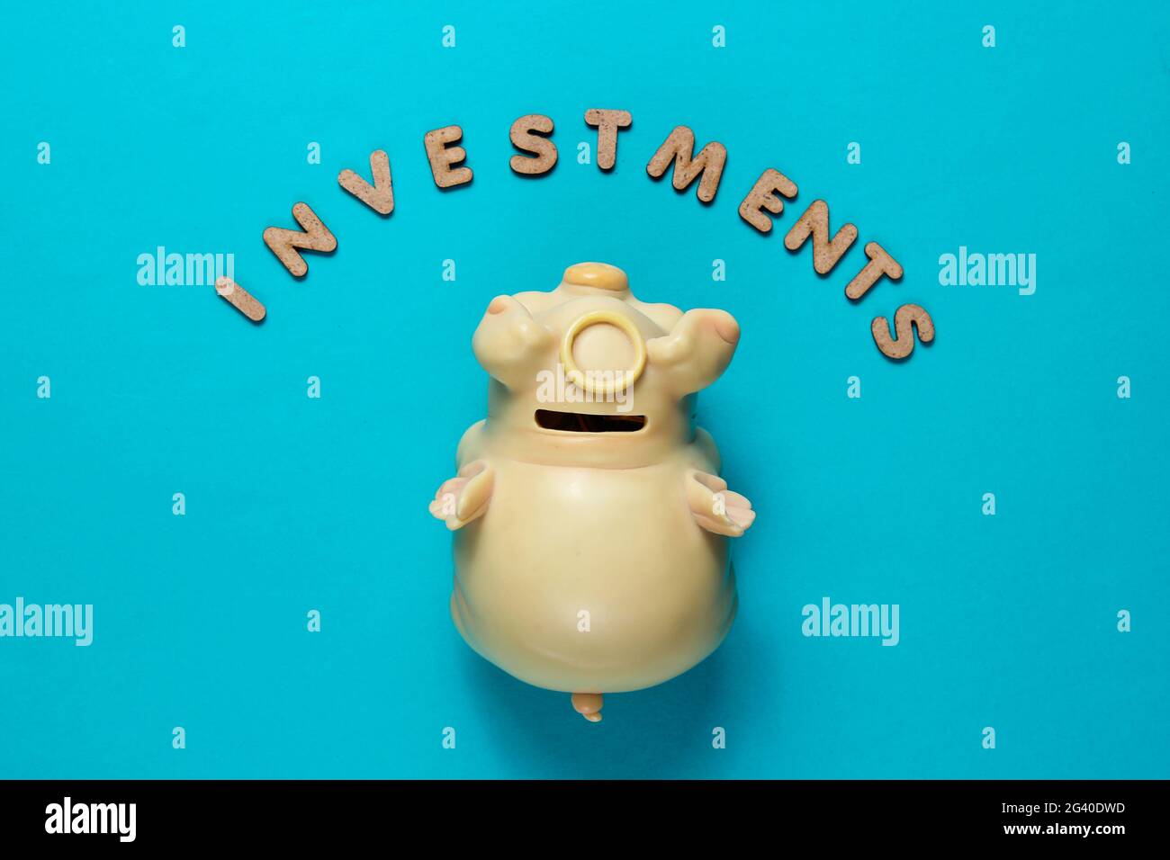 Piggy bank on blue background with text investments with letters. Top ...