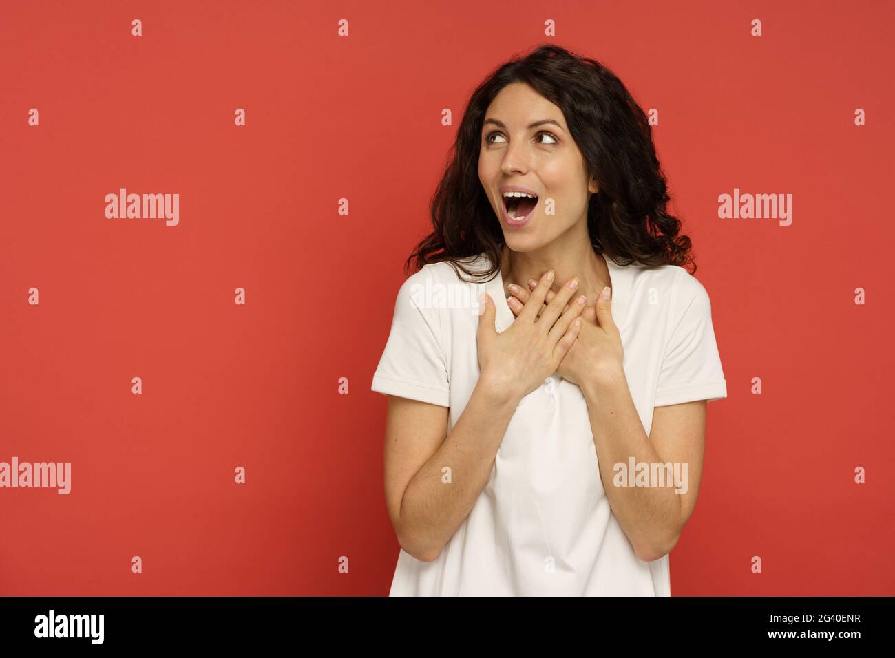 Amazed excited woman hold hands at chest with excitement look aside to ...