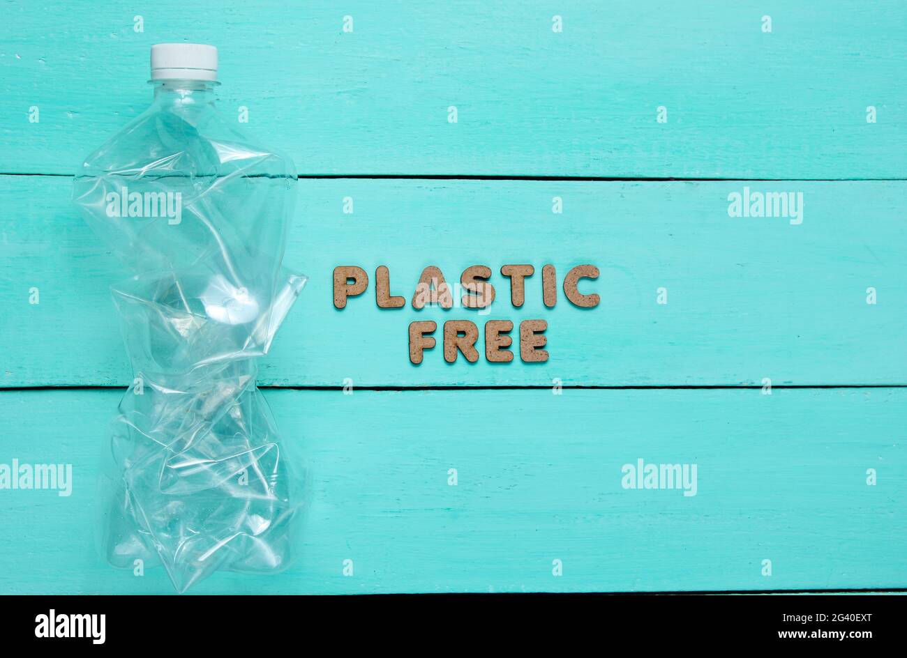 Plastic free concept. Crumpled bottle on a blue wooden background with ...