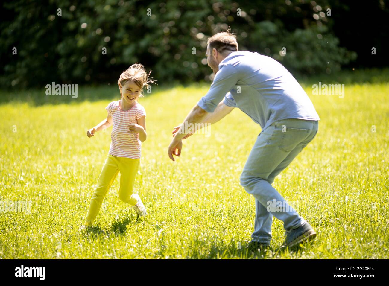 Father chasing his cute little daughter while playing in the park Stock ...