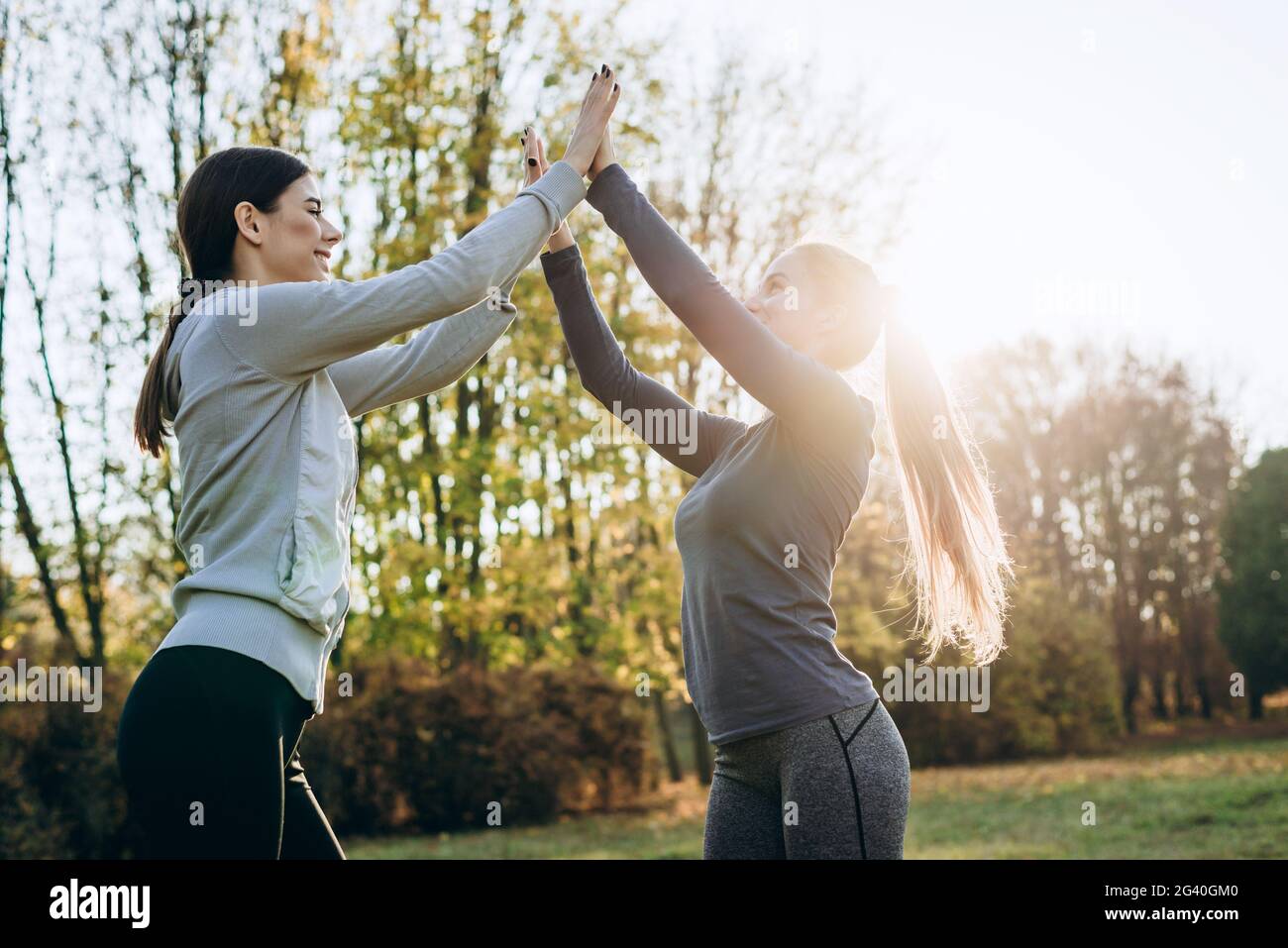 Young girls raising their hands up, jointly perform gymnastic exercises ...