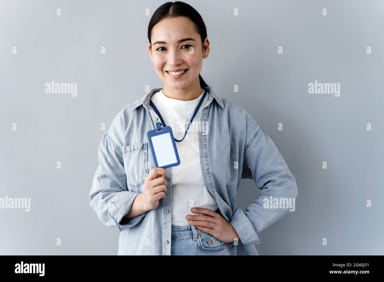 Pretty woman showing name tag on gray background. Close view, blank ...