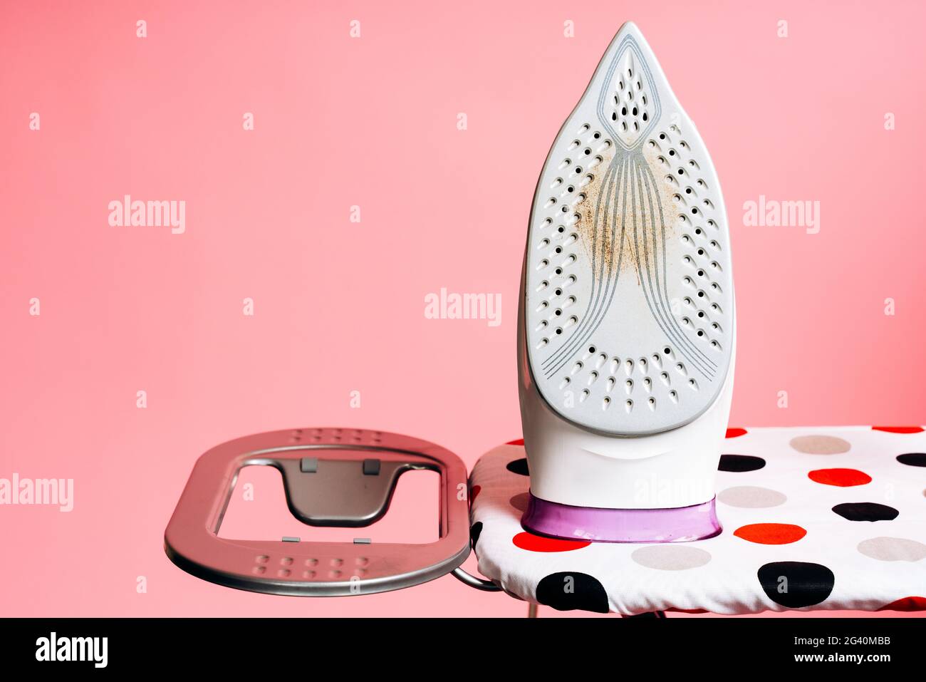 Iron on ironing board on pink background. Homework concept Stock Photo ...