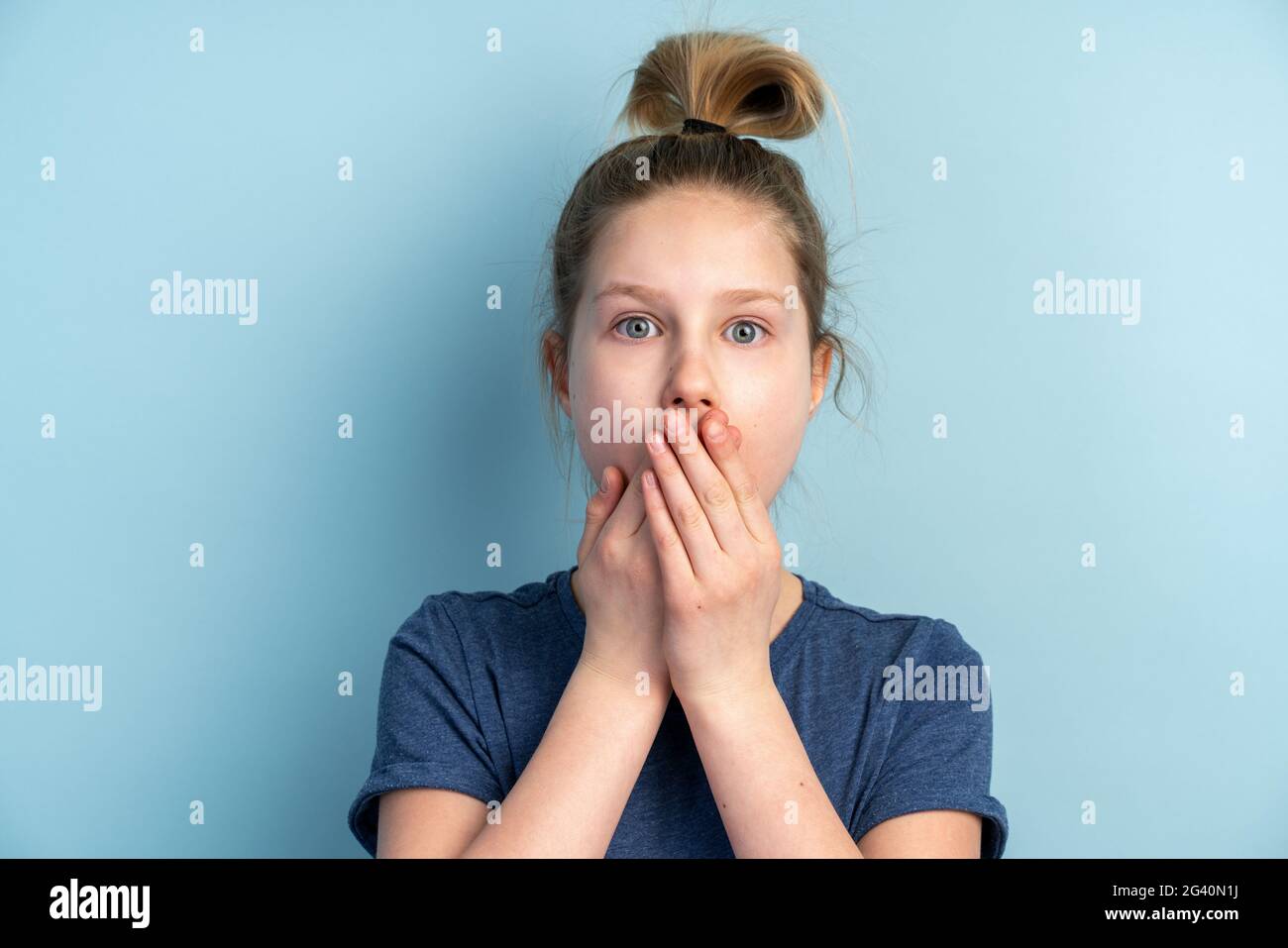Scared teenage girl covers her mouth with her hands. Cute little girl ...