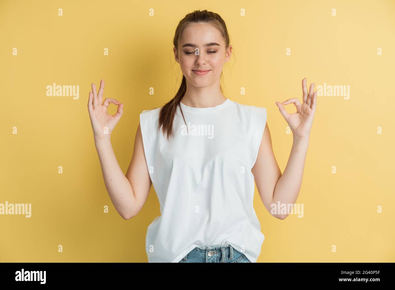 Relaxed girl in sweater posing isolated on yellow orange background ...