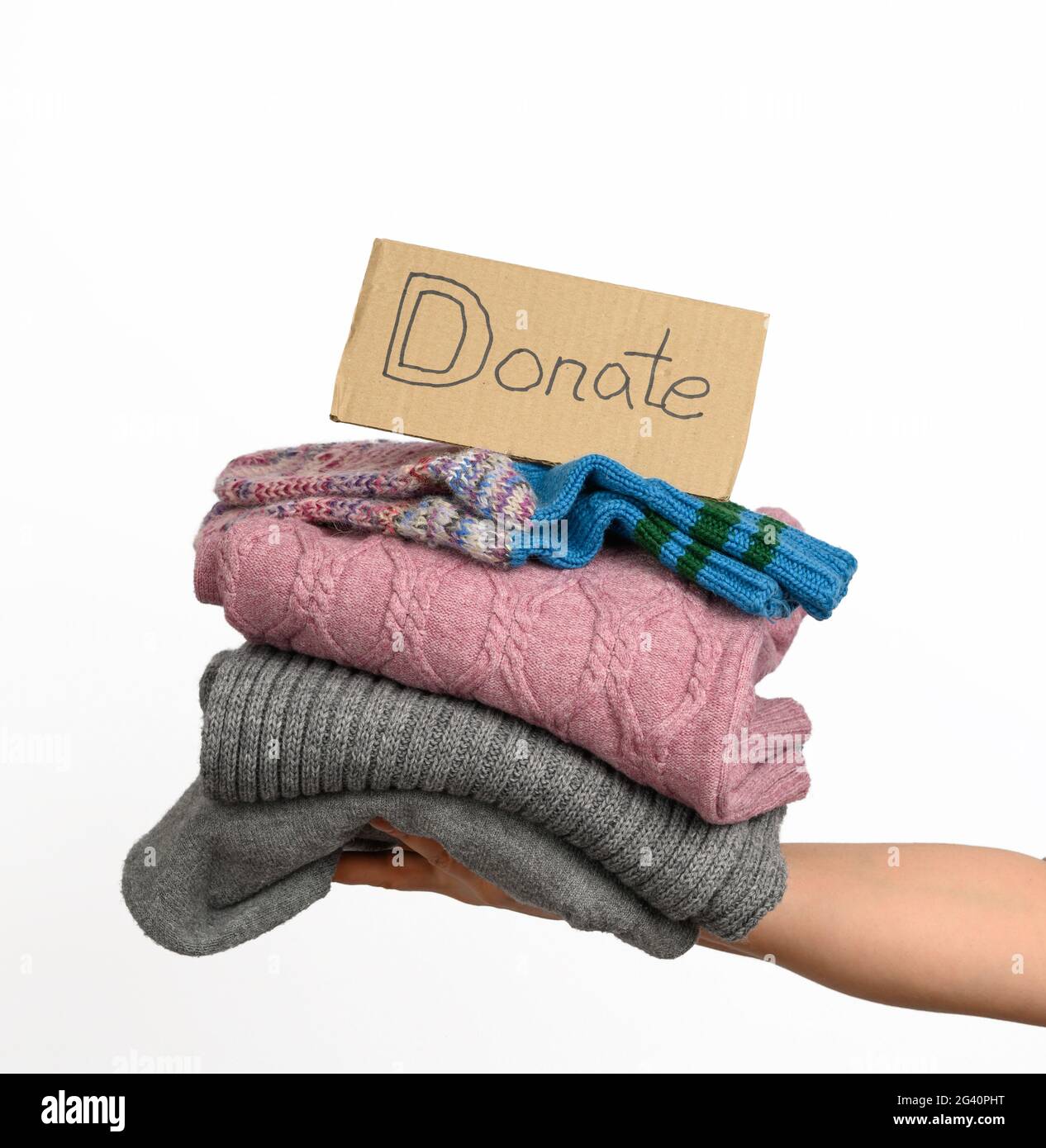 Female hand holding a stack of clothes, help and volunteering concept ...