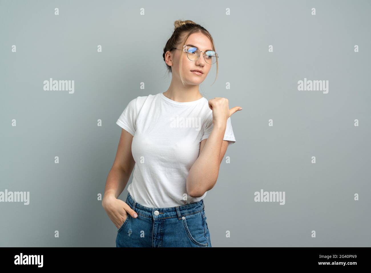 Check this out! Young cheerful lady in casual wear is pointing at te ...