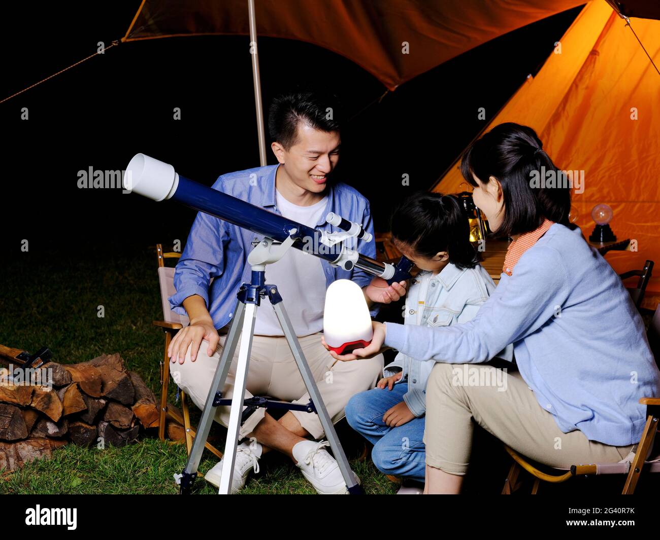 A happy family of three using telescopes outdoors high quality photo ...