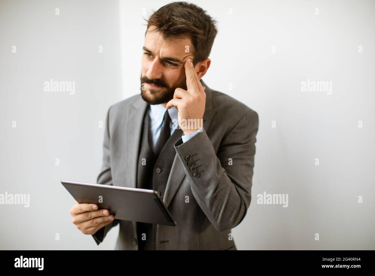Handsome young modern businessman using digital tablet in the office ...