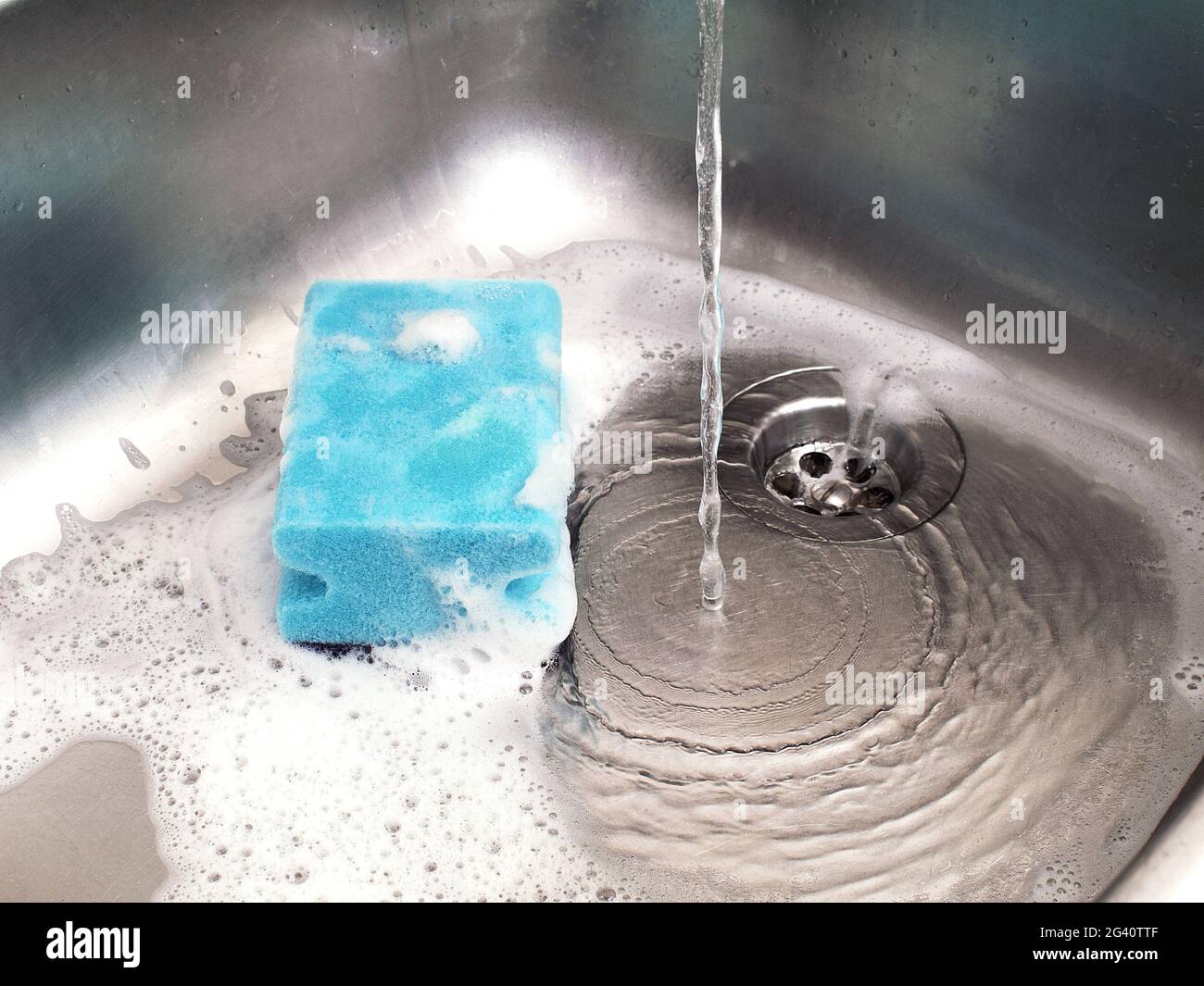sponge in kitchen sink under running water Stock Photo - Alamy