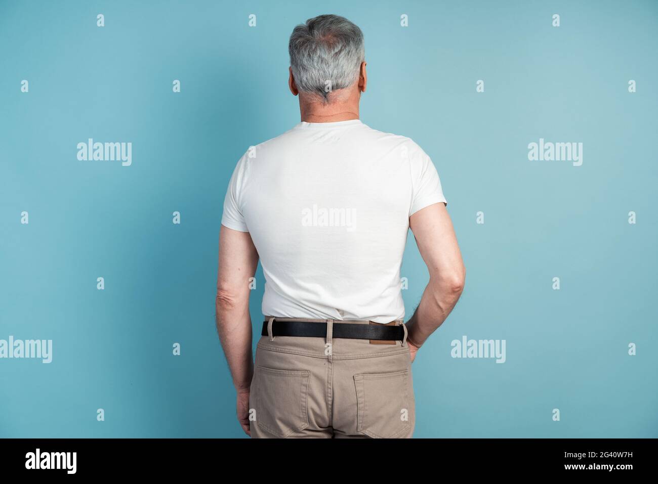 Rear view, a man in a white T-shirt with his back to the camera. Senior ...