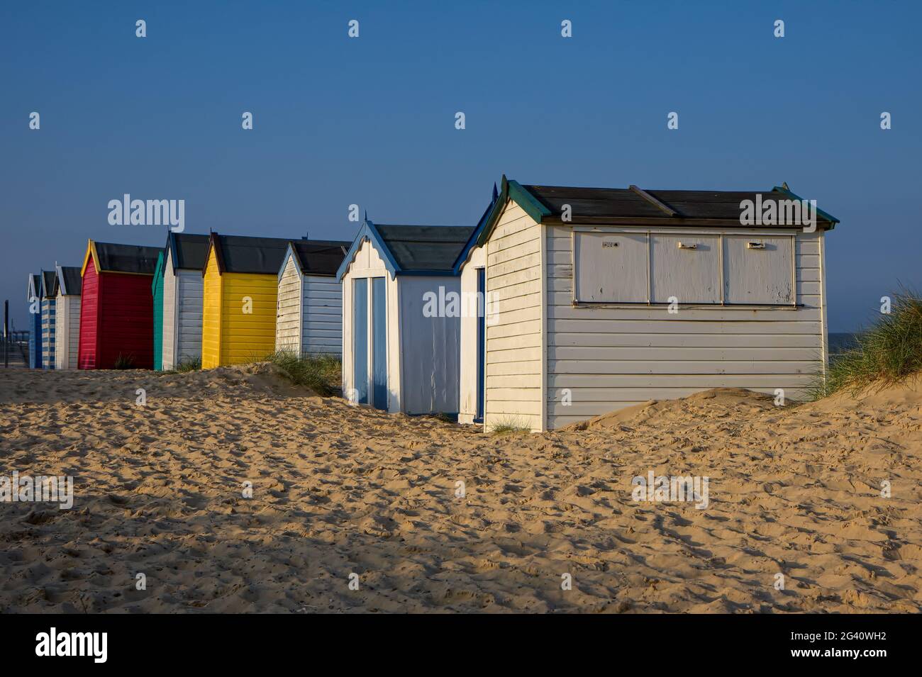 Row of colourful wooden beach huts hi-res stock photography and images ...