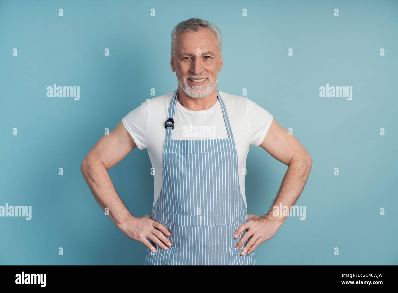 Older, elderly man with his hair and beard wears an apron. Man isolated ...