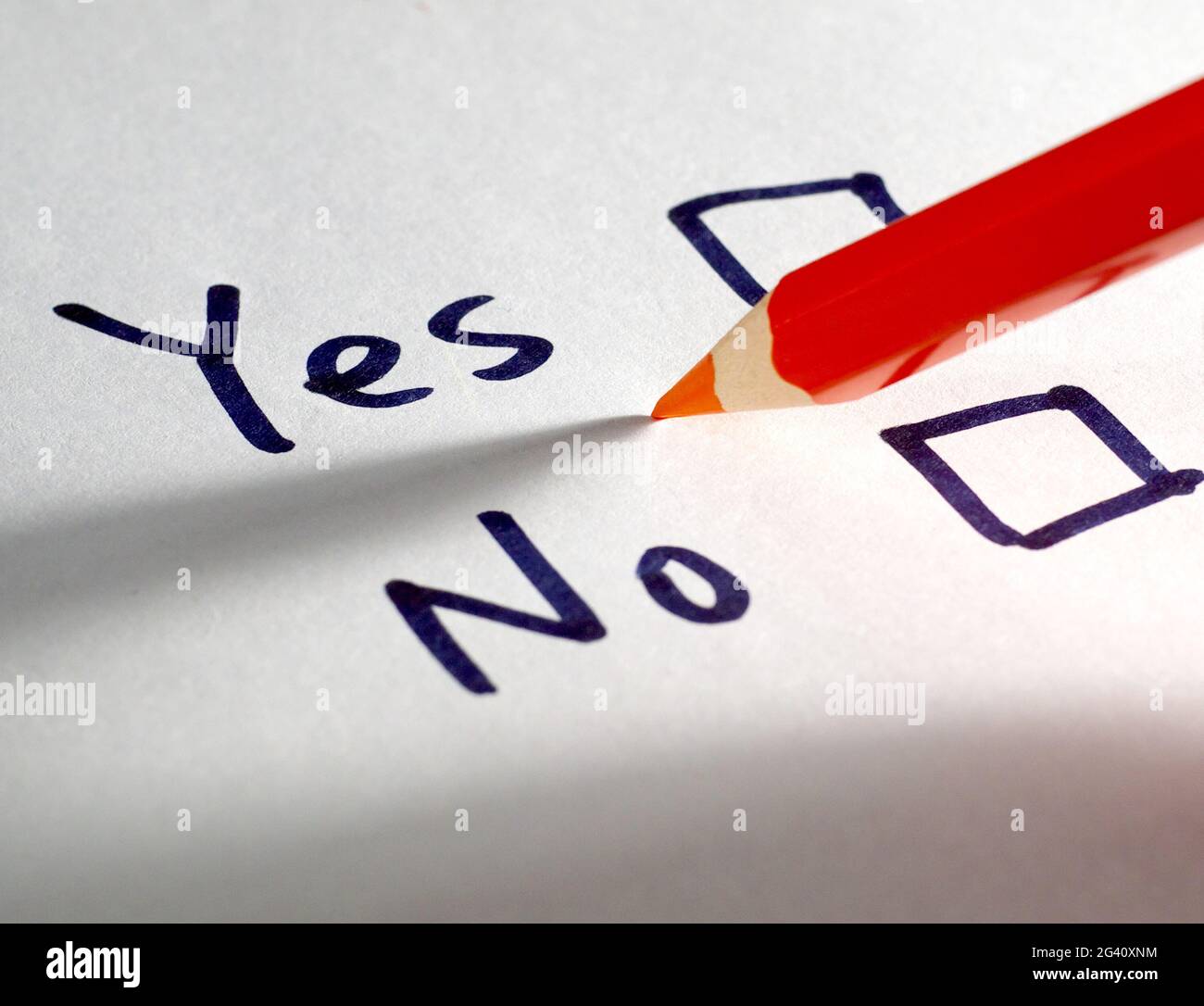 yes and no check boxes on white paper and red pencil under side light ...