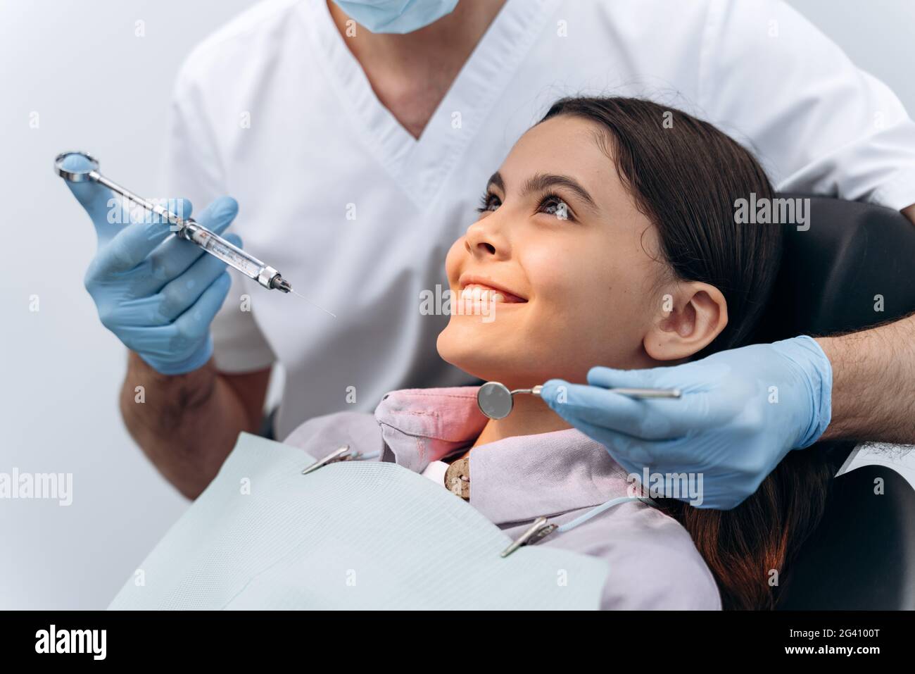 Smiling girl trusts her doctor. The young patient is not afraid of ...