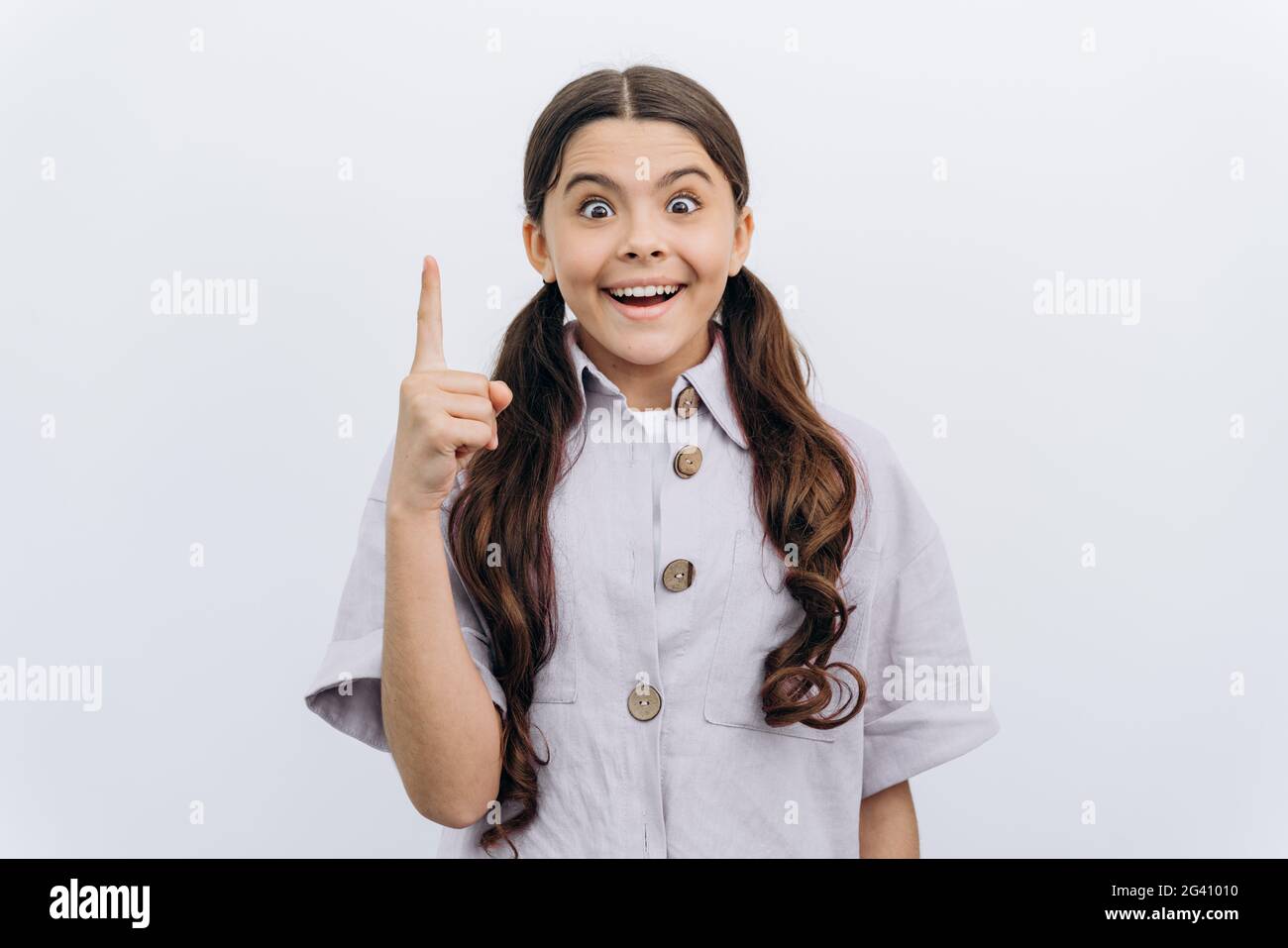 Beautiful, positive girl raised her finger up. The girl on a white ...