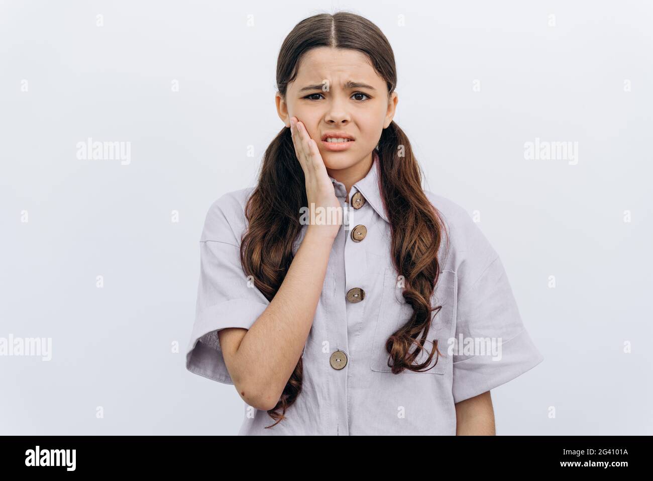 Girl touches her cheek with her hand, winces from a toothache. Cute ...