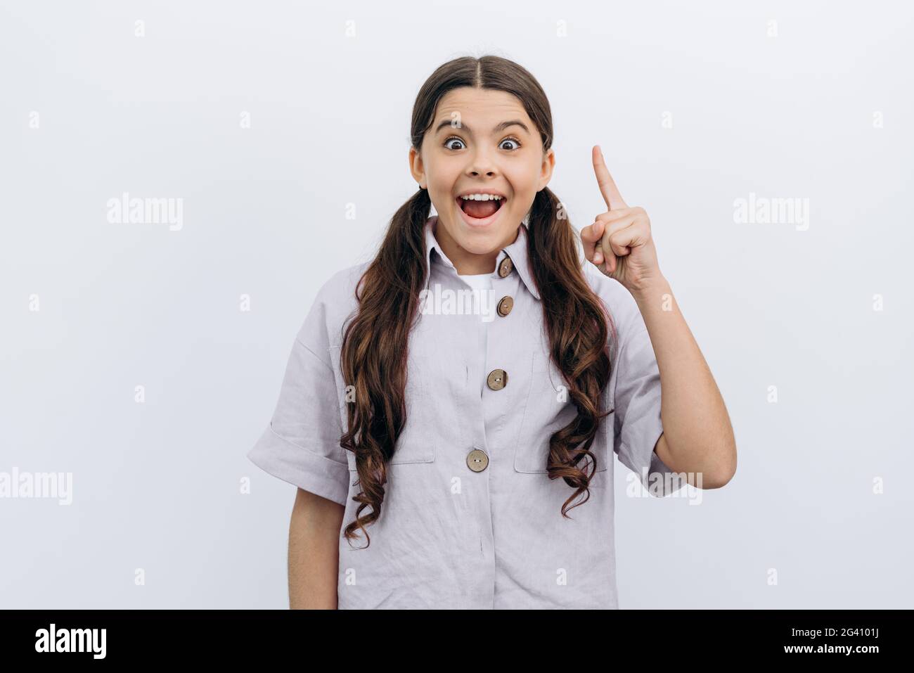 Cute, smiling, positive teen girl raised her finger up. The girl has an ...