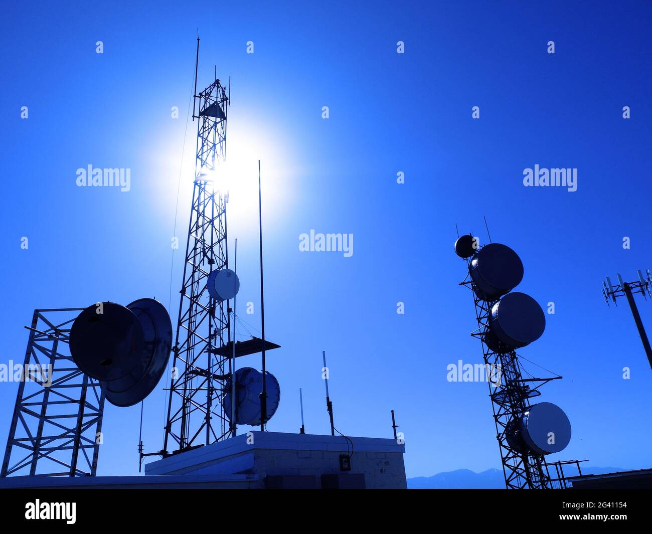 Radio towers for telecommunications and transmissions with blue sky and ...