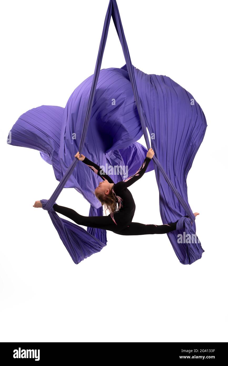 Flexible woman doing aerial silks trick on fabric Stock Photo - Alamy