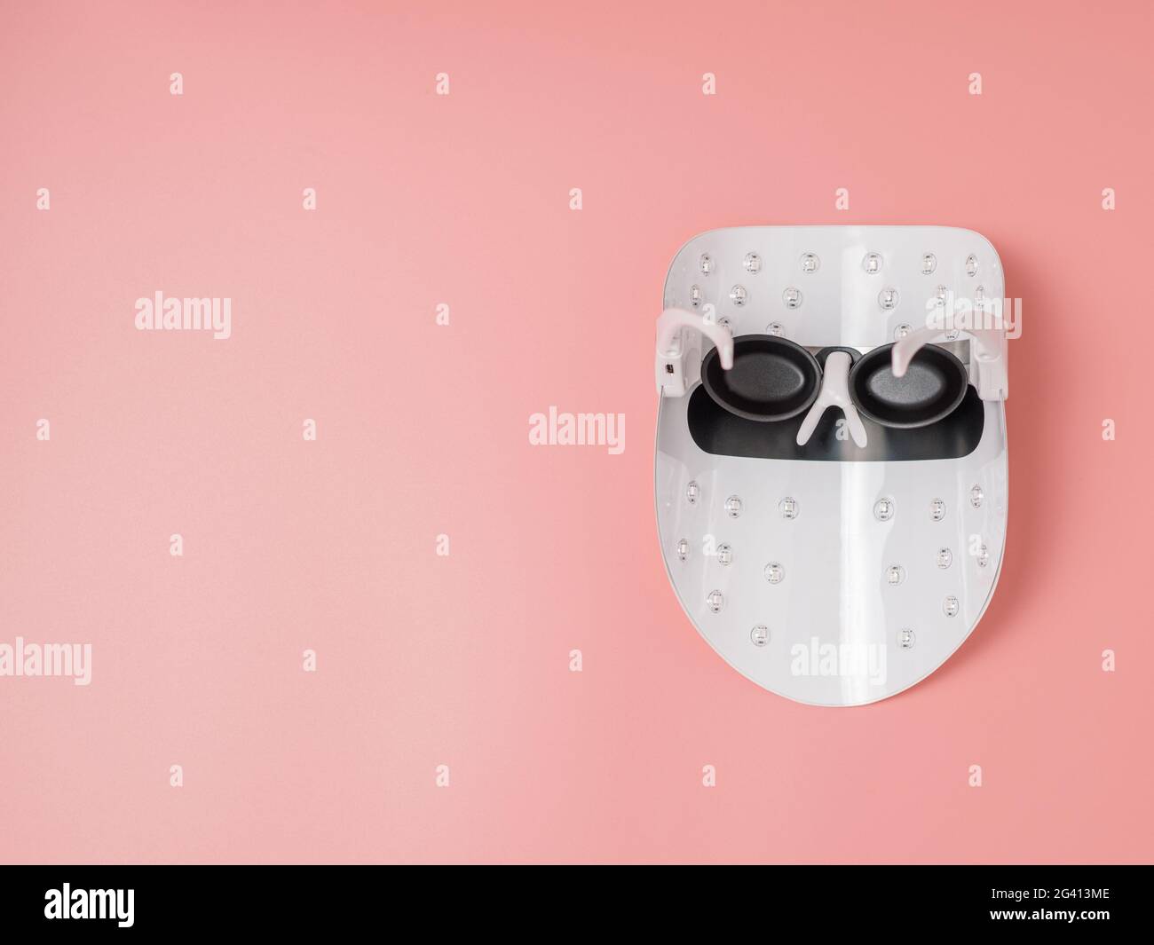Led light face mask on pink background, copy space Stock Photo - Alamy