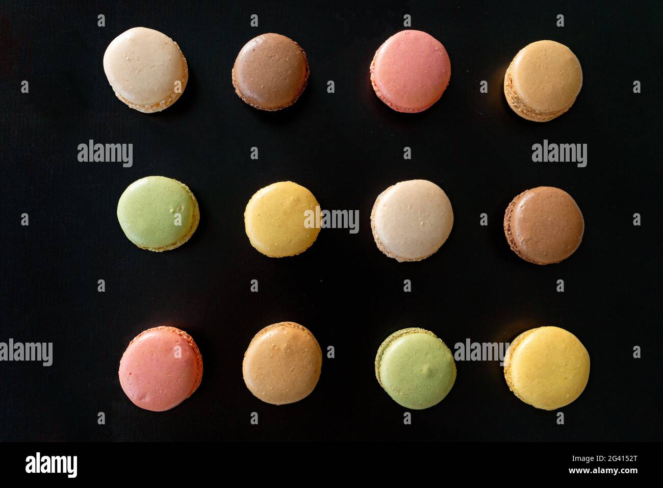 Macarons top view on black background. Baking sheet fresh out of the ...