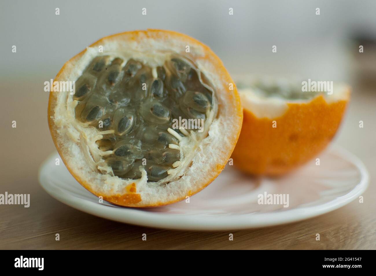 Fresh organic ripe granadilla or yellow passion fruit cut in half on a ...