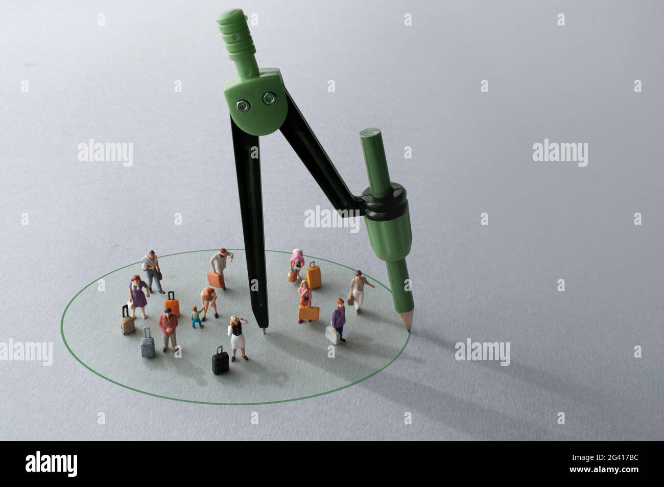 Compass with green pencil circle around miniature travellers ...