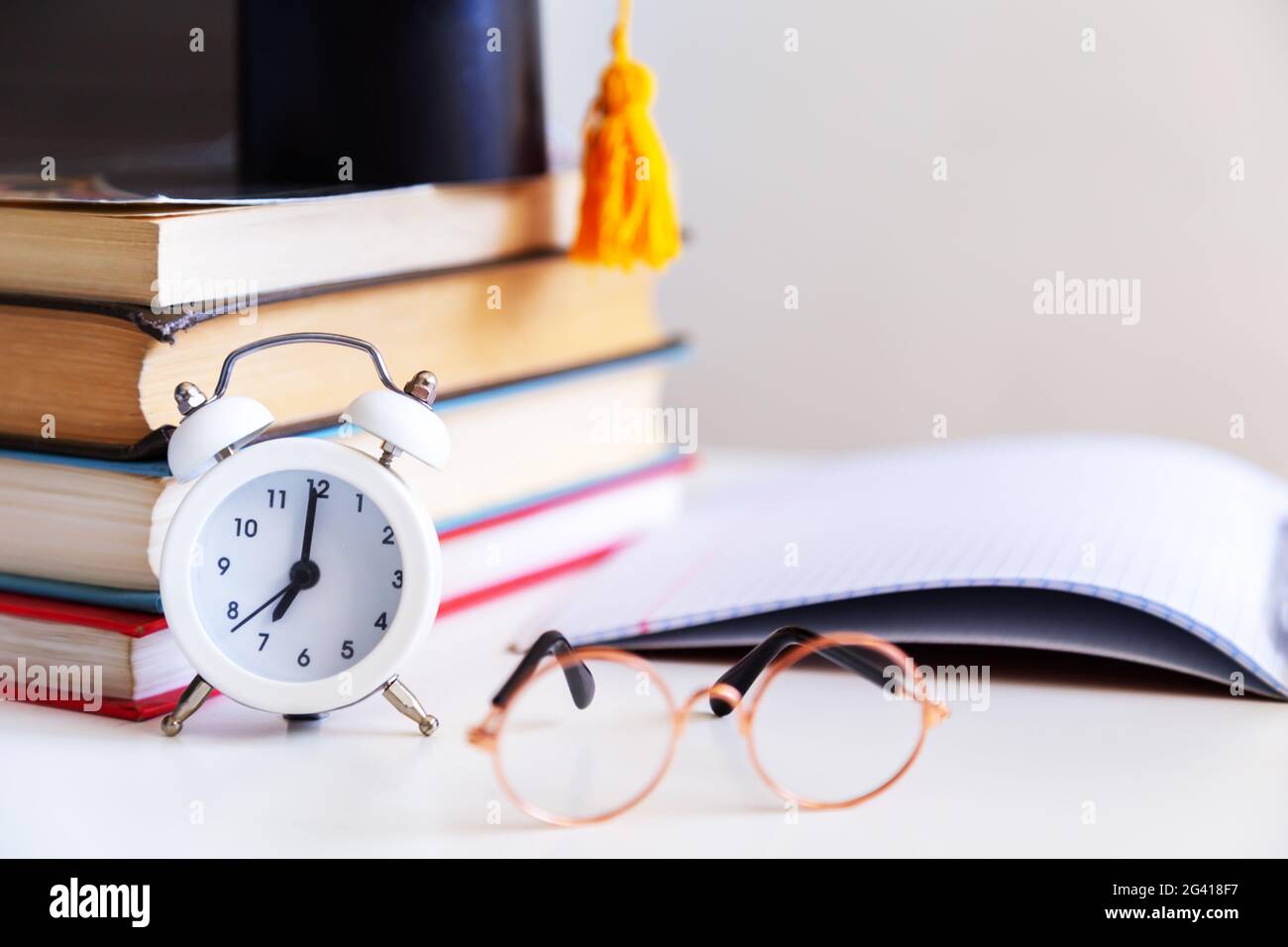 Books, writing materials, glasses, notebook and alarm clock on the ...