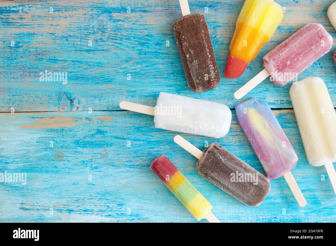 Frozen assorted ice lollies on a wooden background Stock Photo - Alamy
