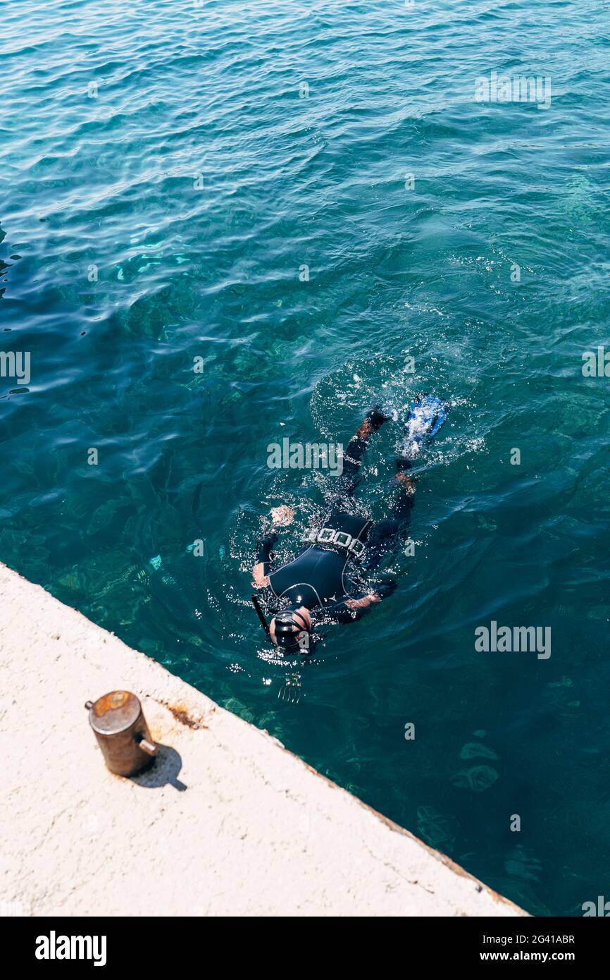 A diver in a diving suit with weights, fins and a mask with a snorkel ...