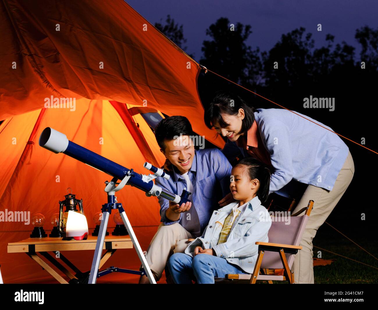 A happy family of three using telescopes outdoors high quality photo ...