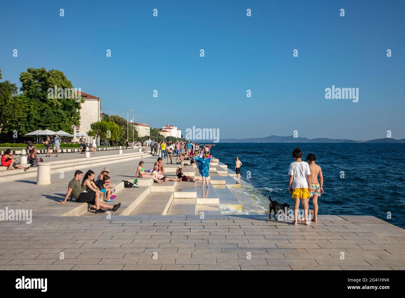 People relax on the beach promenade and listen to the sea organ, Zadar ...