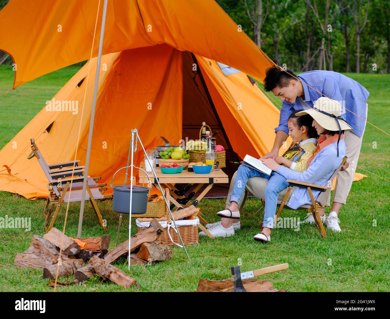 A happy family of three reading outside high quality photo Stock Photo ...