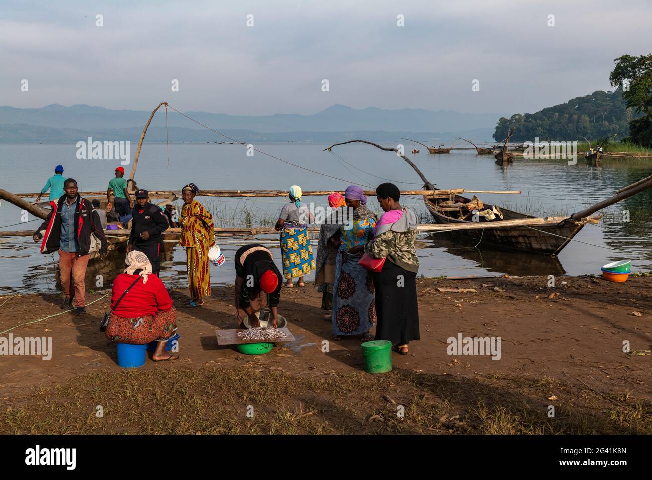 Women with baskets of sambaza fish caught by singing fishermen at Lake ...
