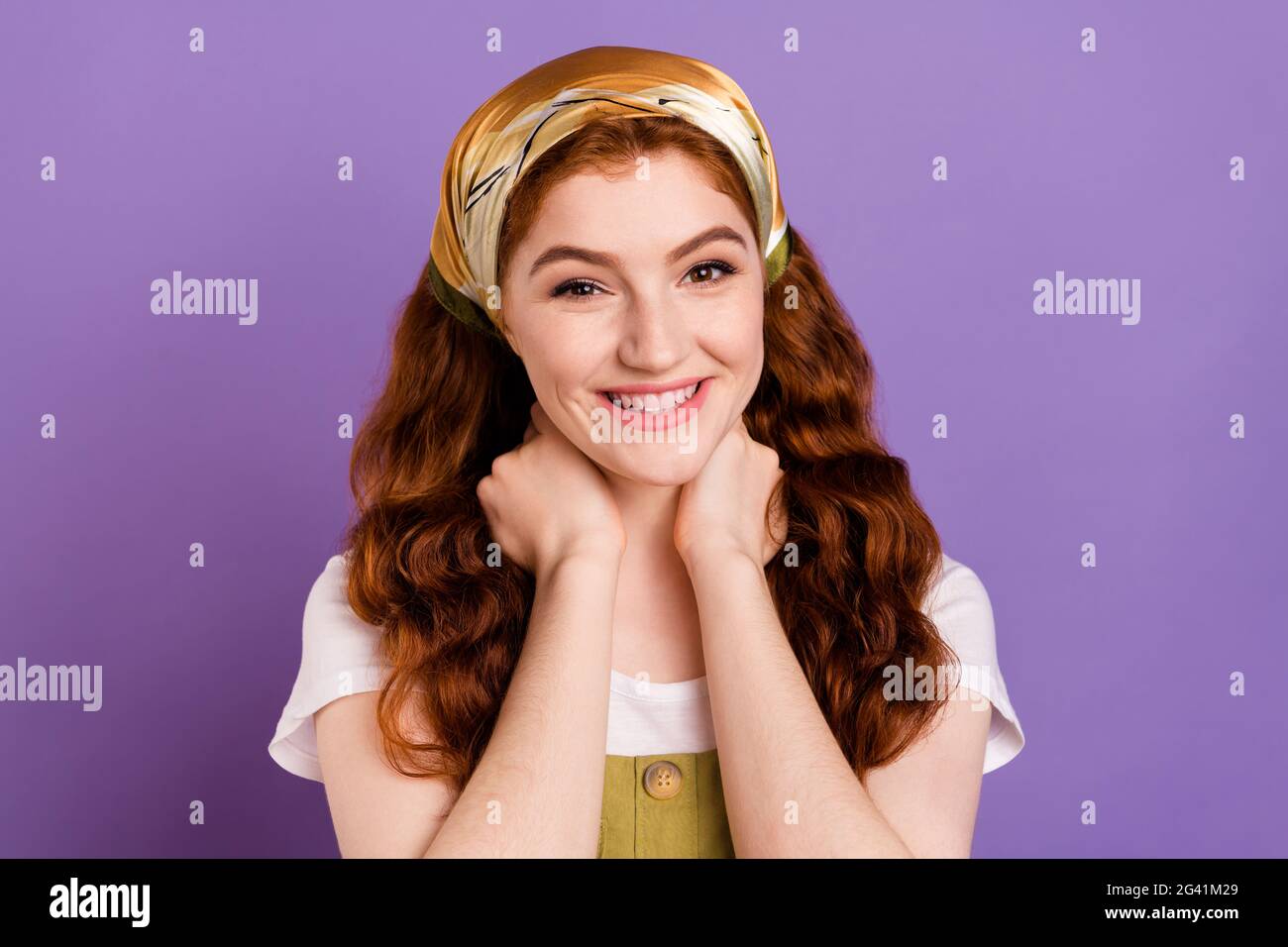 Photo of happy young nice shy woman hold hands neck smile wear bandana ...