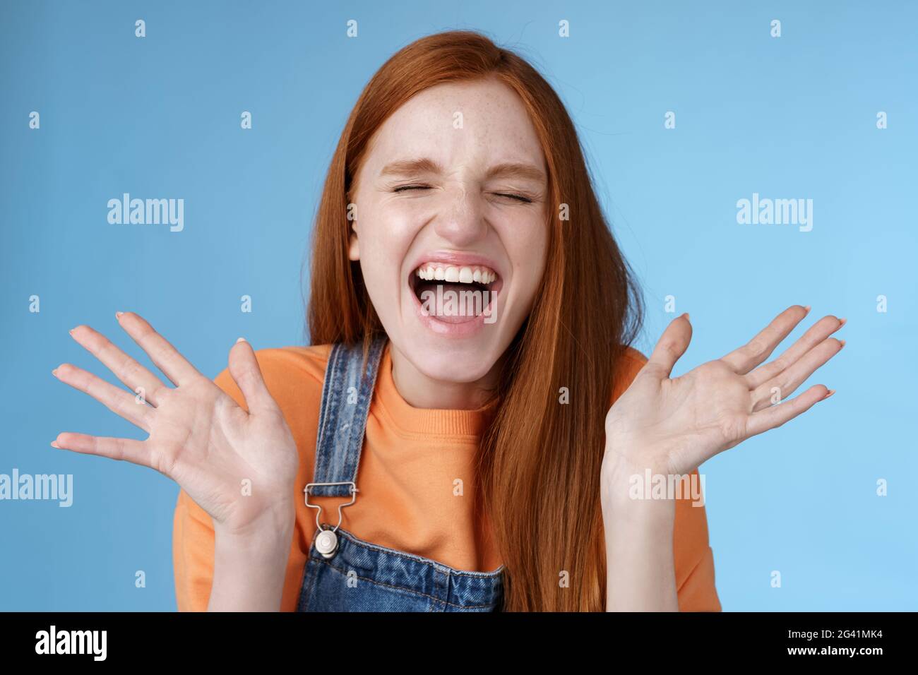 Positive carefree triumphing young attractive redhead girl scream out ...