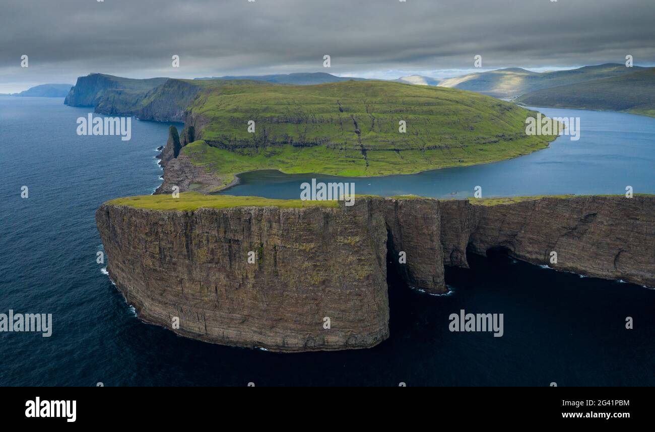Coast, waterfall and cliffs at Trælanípa on the island of Vagar, on ...
