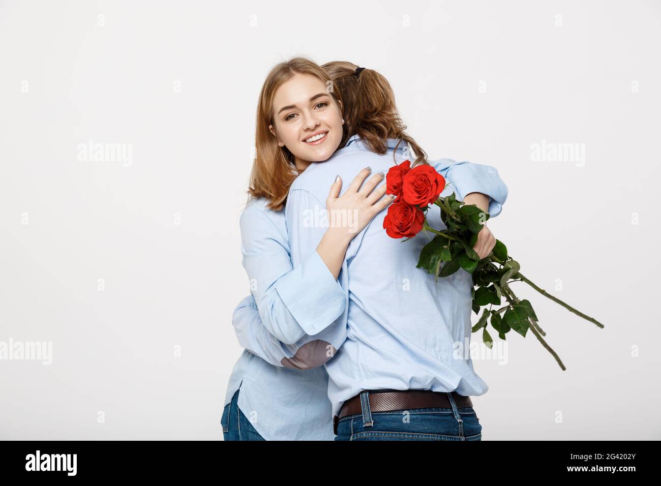 Portrait of an attractive young man hiding flowers from his girlfriend ...